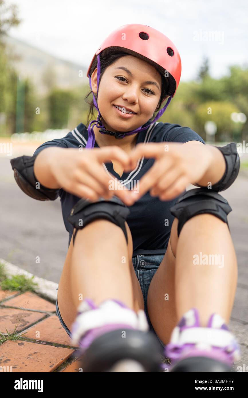 A beautiful girl forms a heart shape with her fingers, expressing love and positivity in a ...