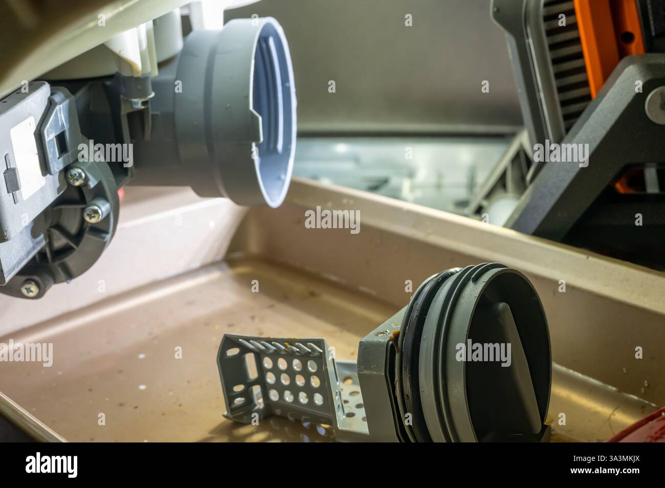 Cleaning and draining a clothes washing machine filter Stock Photo - Alamy