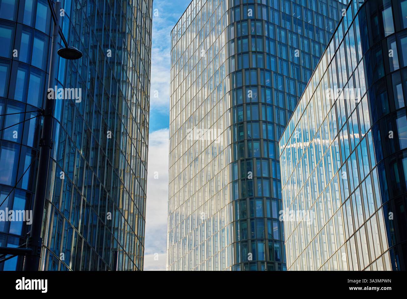 Modern glass skyscrapers reflecting blue sky and surrounding city. High ...