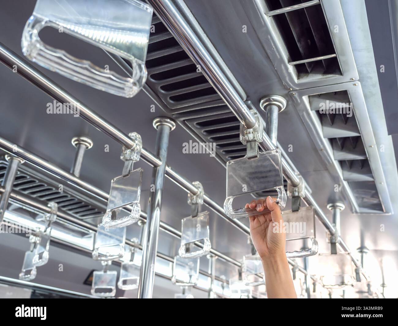 Hand holding empty clear plastic frame, bus handle, hanging straps ...