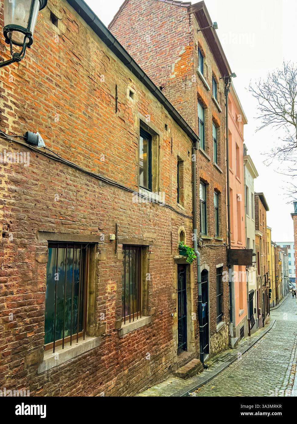 Old brick building facade in brussels with cobblestone street view ...