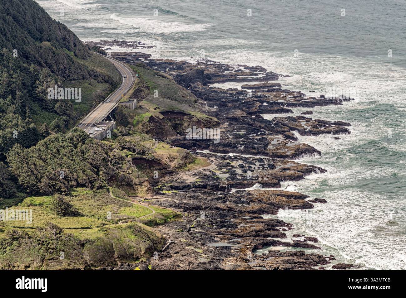 An aerial view of the arch bridge and rocky shoreline at Cape Perpetua ...