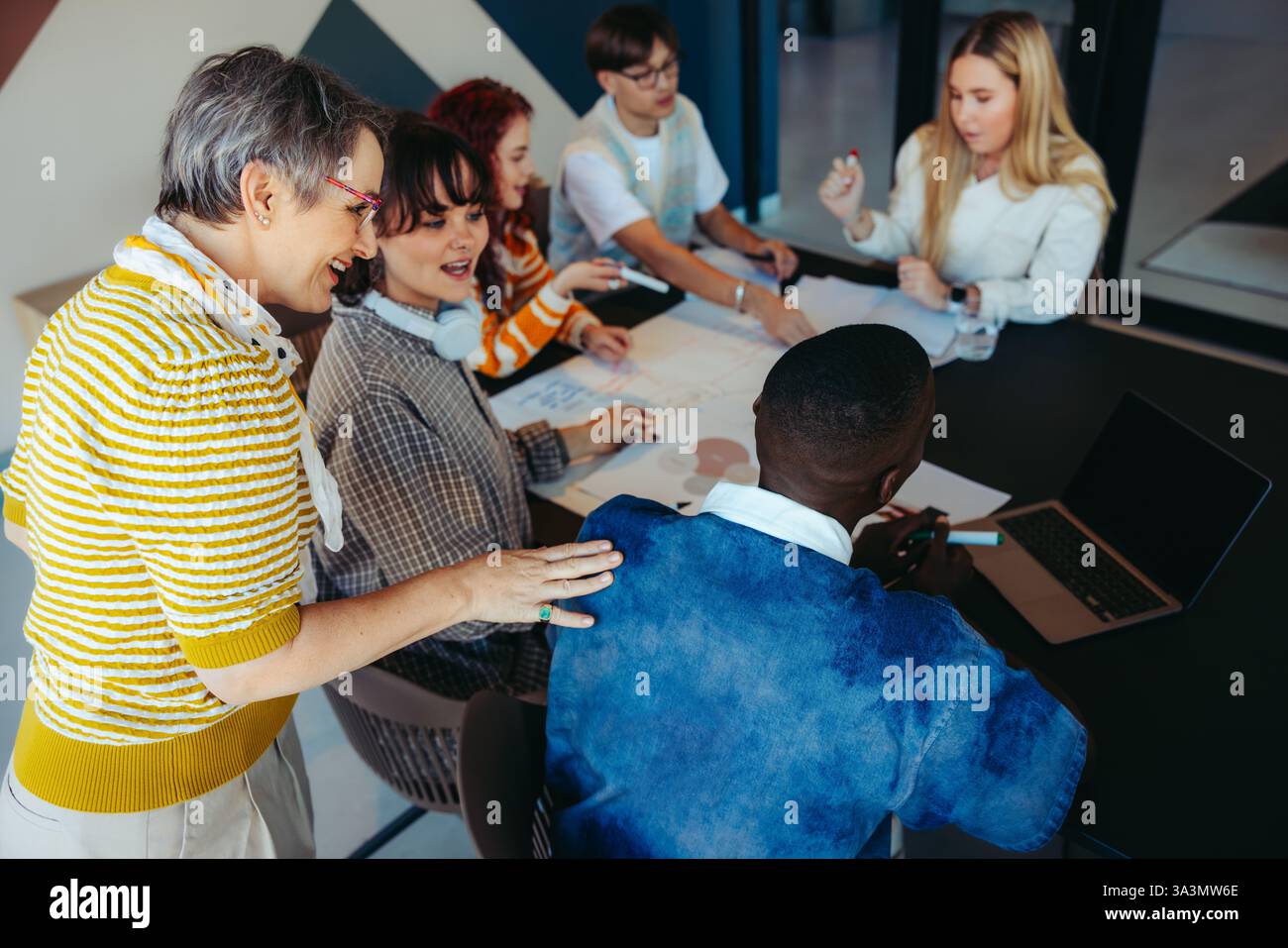 A teacher guides a diverse group of pupils during a collaborative classroom session, fostering ...