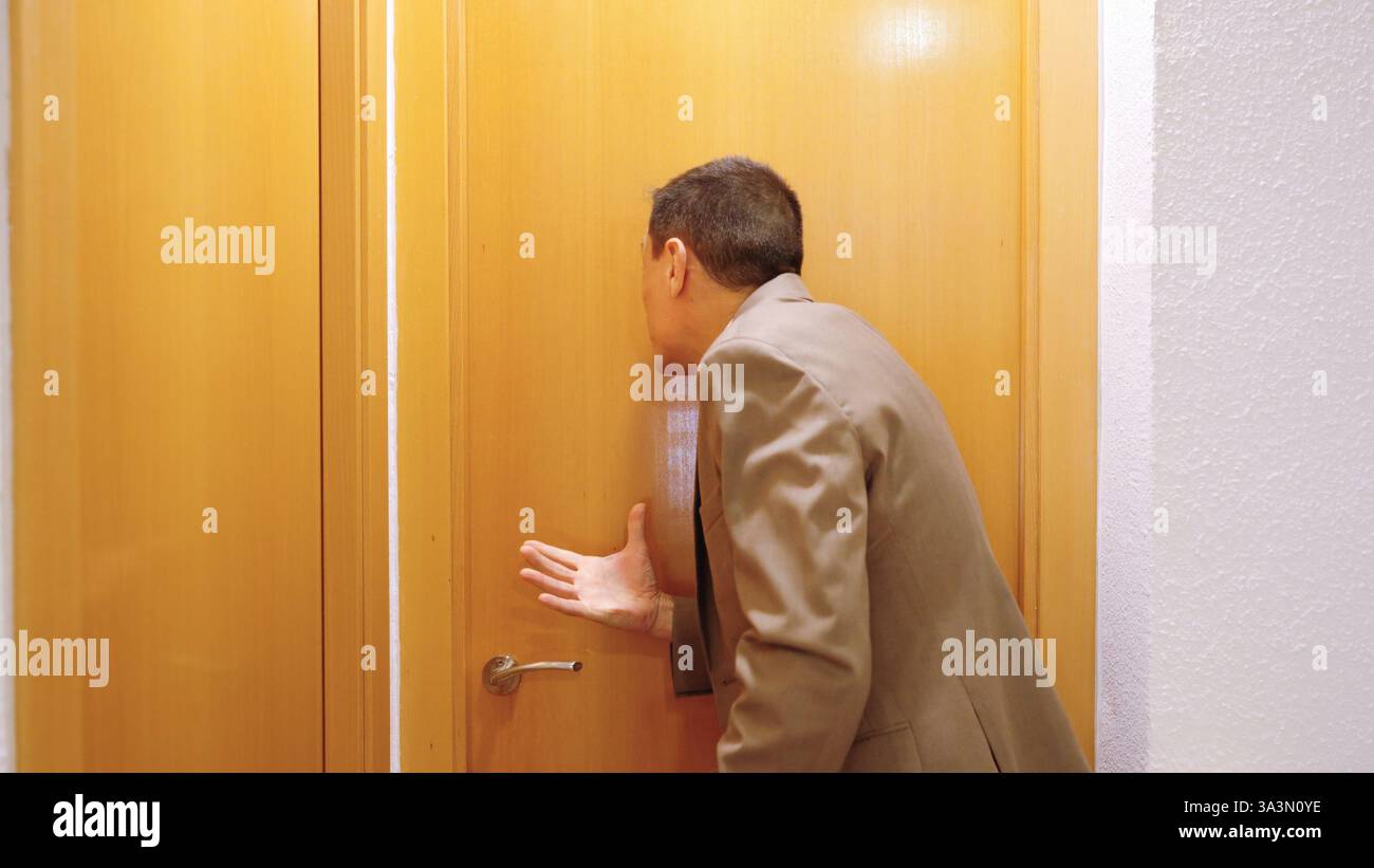 Angry man waiting for wife in front of door Stock Photo - Alamy