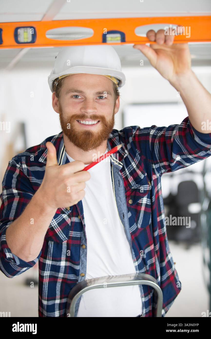 happy man on a ladder showing thumb up Stock Photo - Alamy
