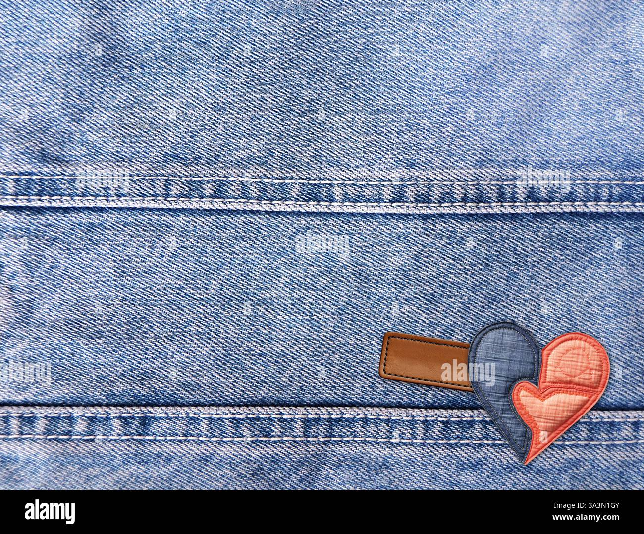 Light blue denim background with felt heart and leather label ...