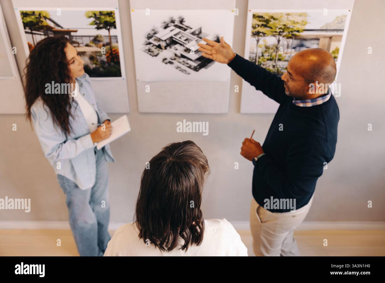 Three professionals discussing and evaluating architectural designs in ...