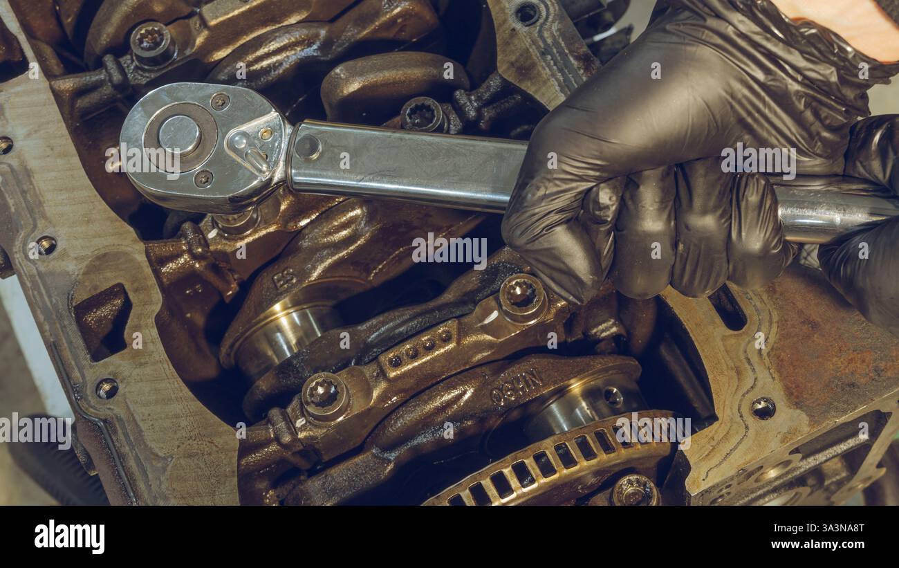 A mechanic working on a car engine in a well-equipped auto repair shop ...