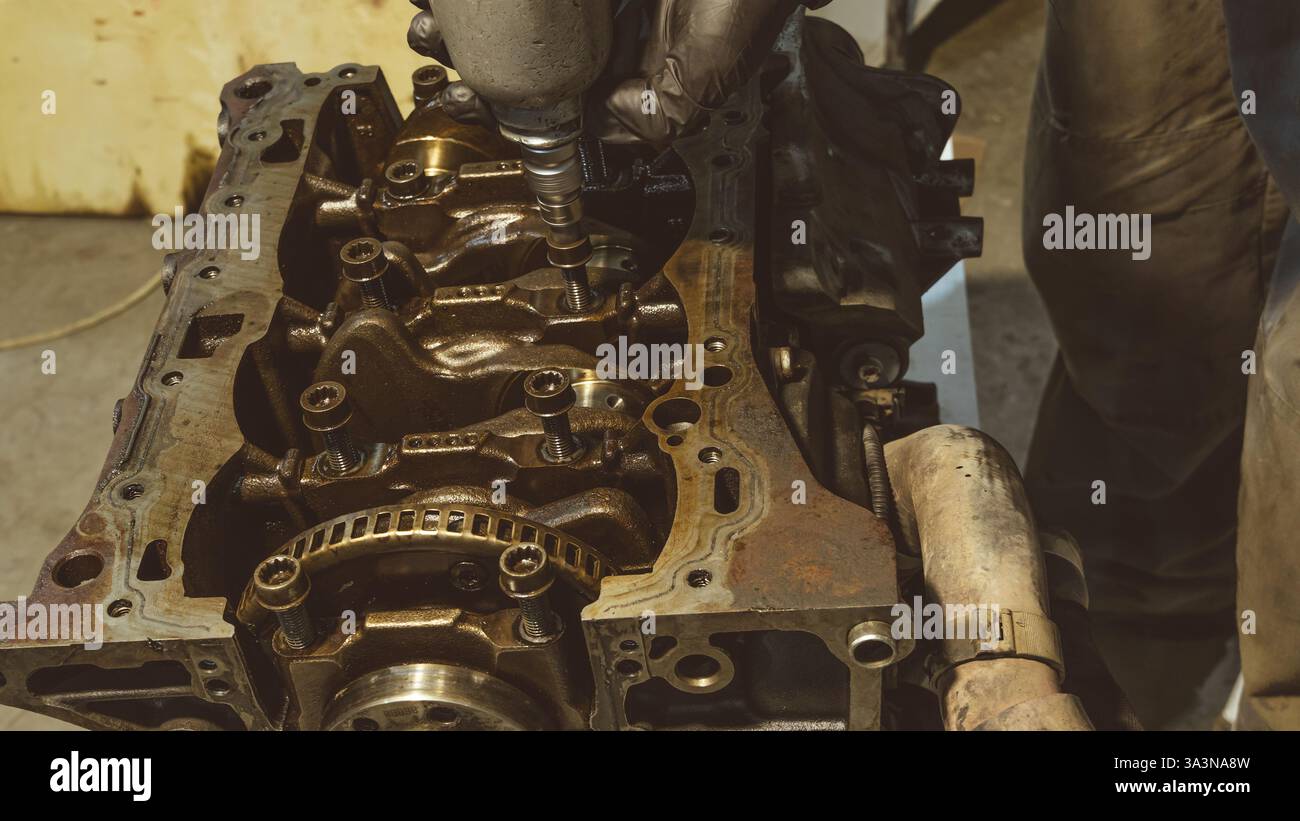 A mechanic working on a car engine in a well-equipped auto repair shop ...