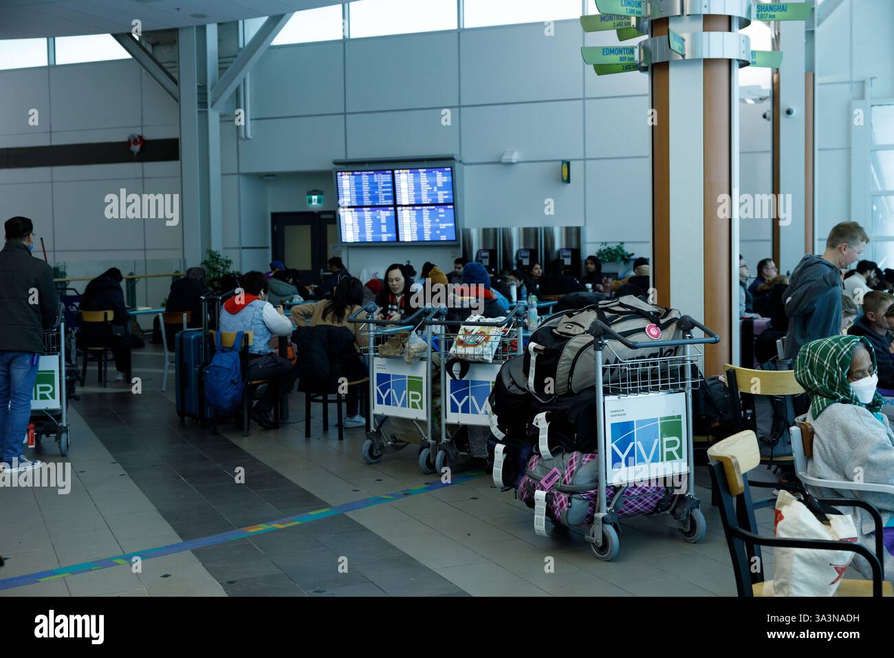 Vancouver, Canada - December 20,2022: Crowded Vancouver International Airport waiting area with ...