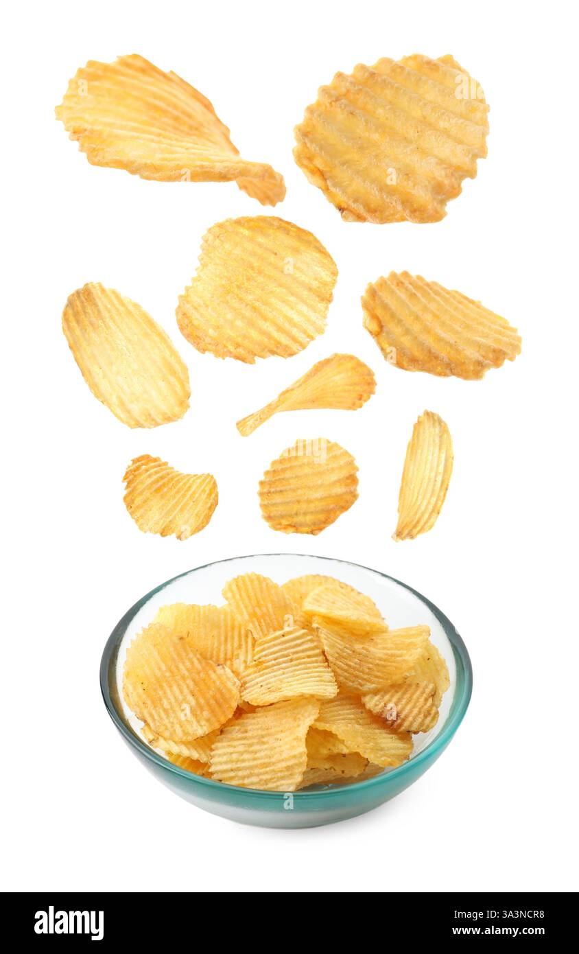 Tasty potato chips falling into bowl on white background Stock Photo ...