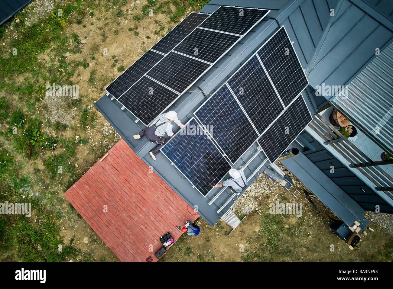 Builders connecting cables while installing photovoltaic solar panels ...