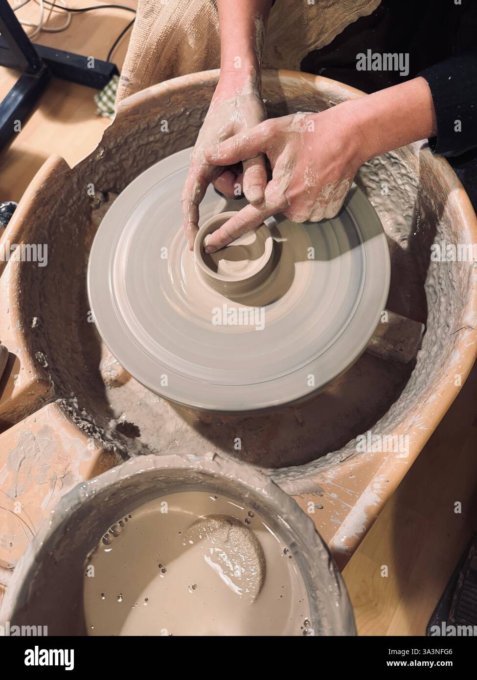 Hands shaping pottery on a spinning wheel in a creative studio Stock ...