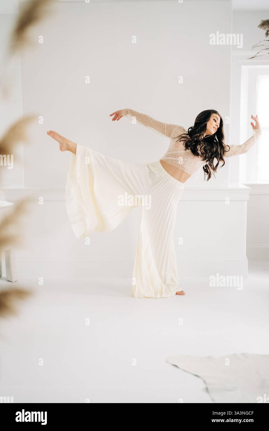 Woman gracefully dancing in a white flowing outfit in a studio Stock ...