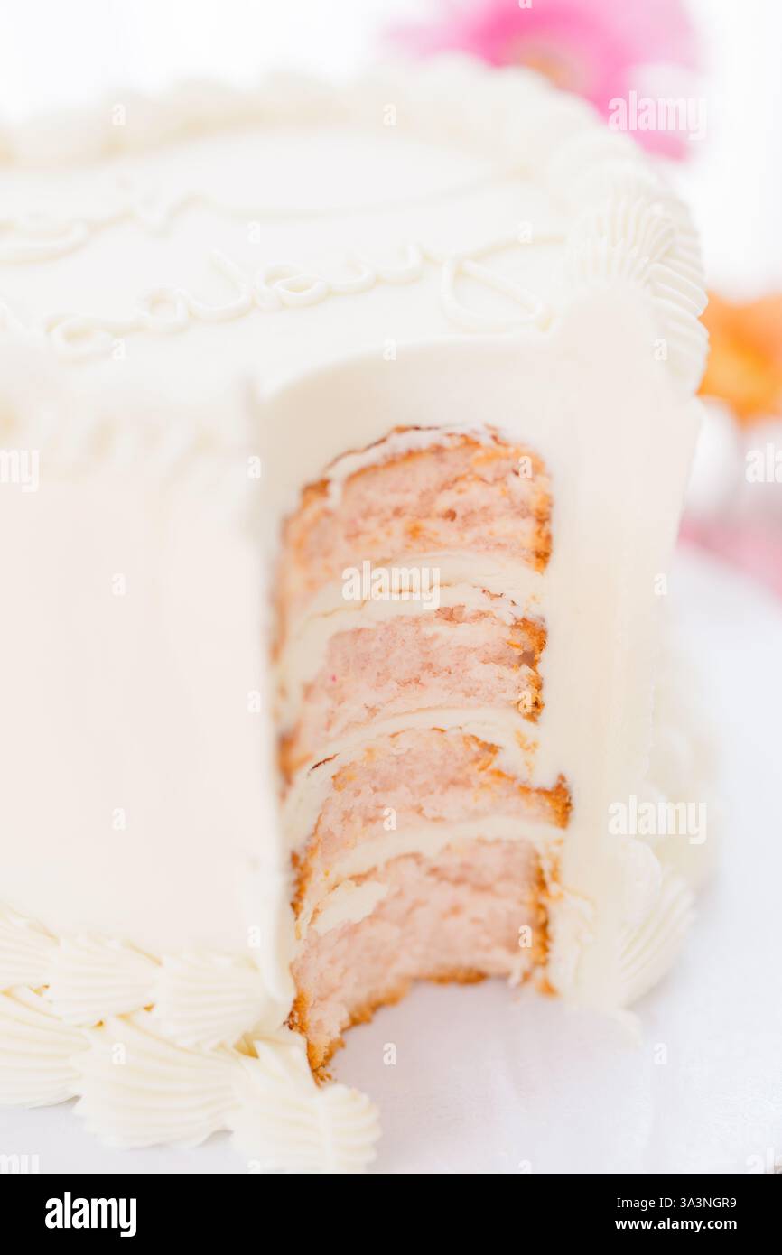 Slice cut from pink-layered cake with white frosting Stock Photo - Alamy