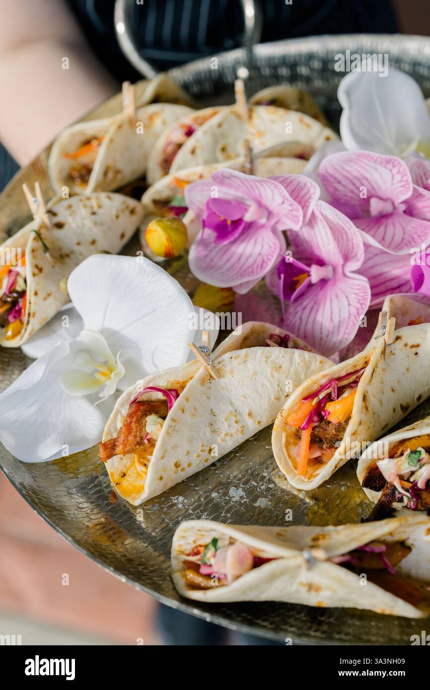 Mini tacos with colorful slaw, served with orchid floral decor Stock ...