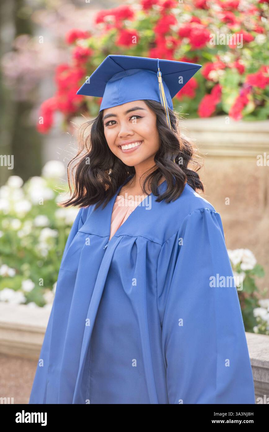 Proud graduate smiles in her blue cap and gown, ready for the future ...