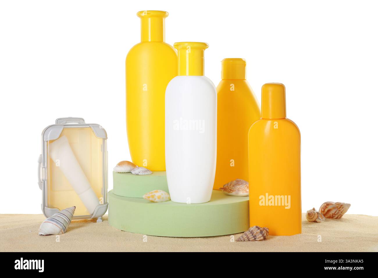 Different sun protection products and seashells on sand against white ...