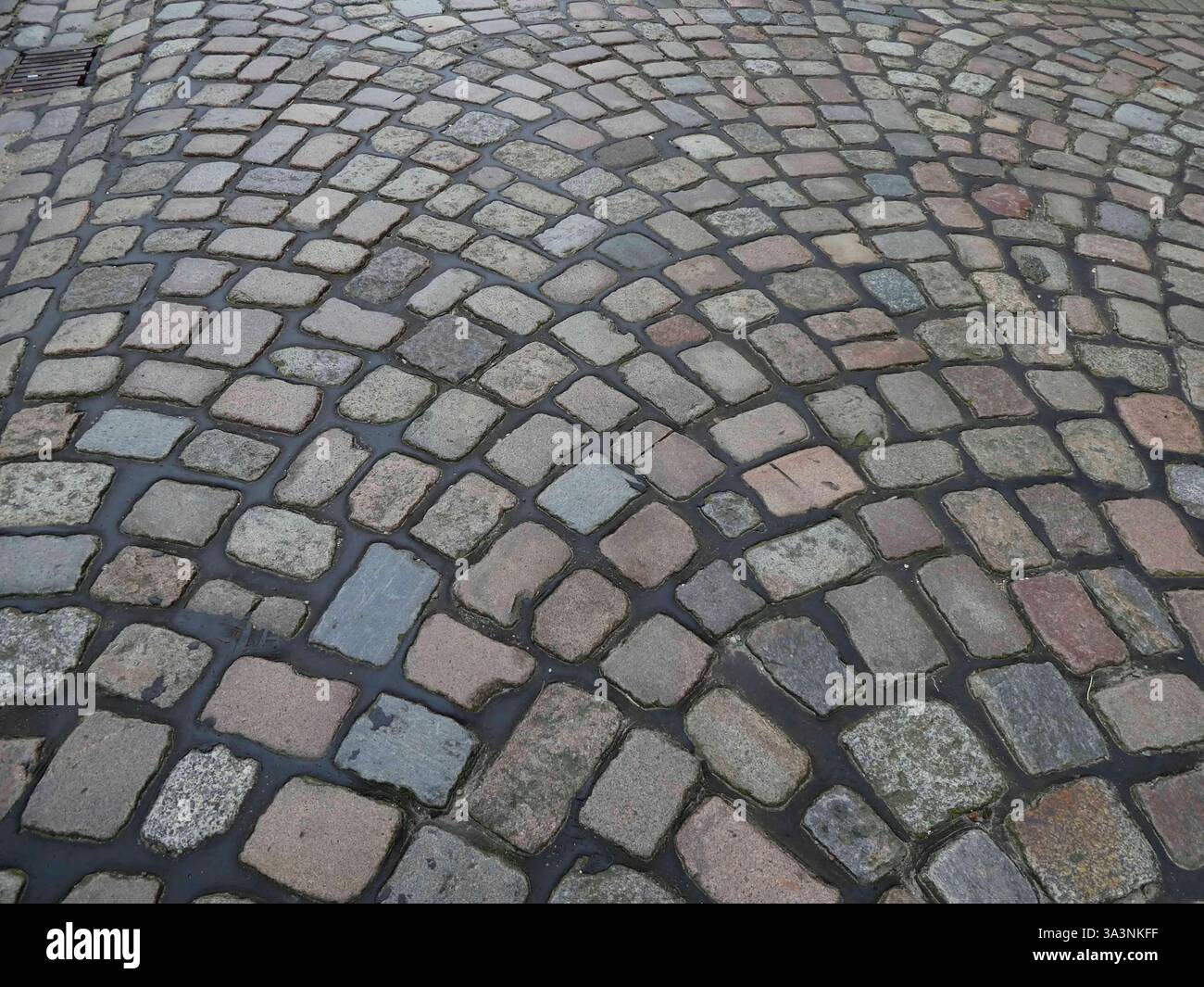 Natur Granit Pflastersteine auf der Strasse in rauher Arbeit Muster als Grosspflaster verlegt ...