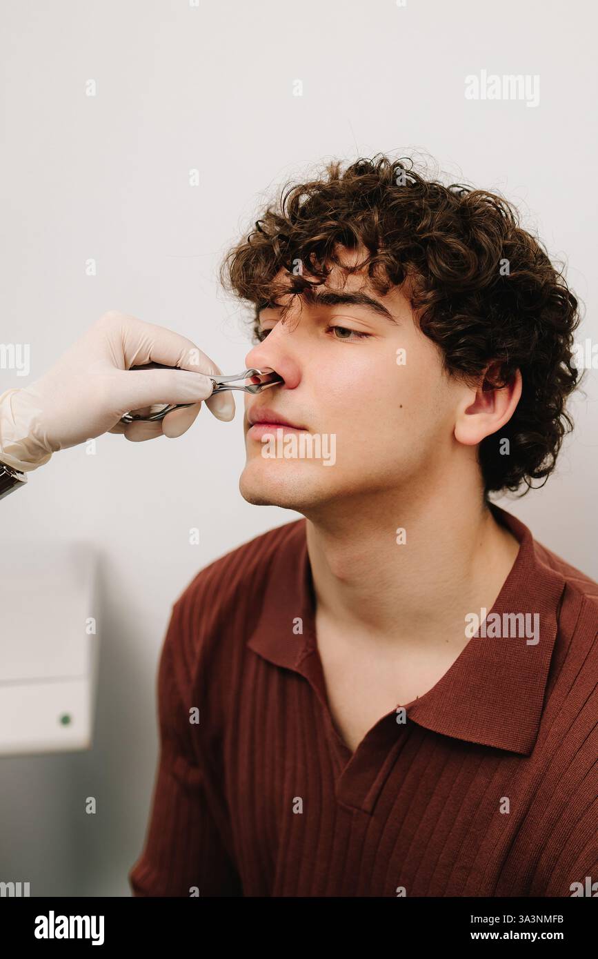 ENT doctor checking nose of man patient with rhinoscope. Rhinoscopy ...