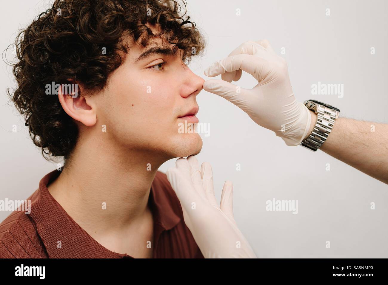 Rhinoplasty surgery preparation for man. ENT is touching nose and ...