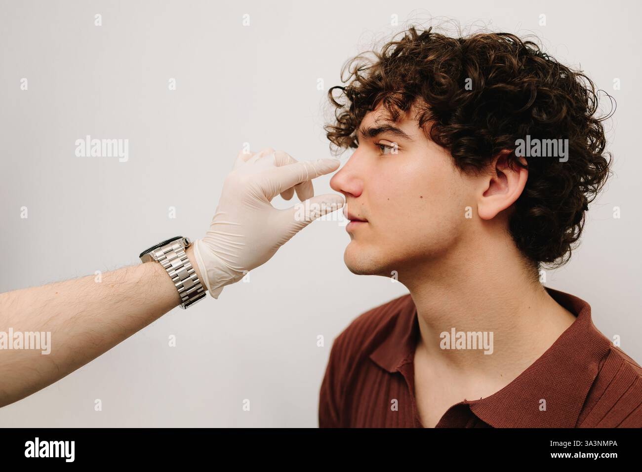 Rhinoplasty surgery preparation for man. ENT is touching nose and ...