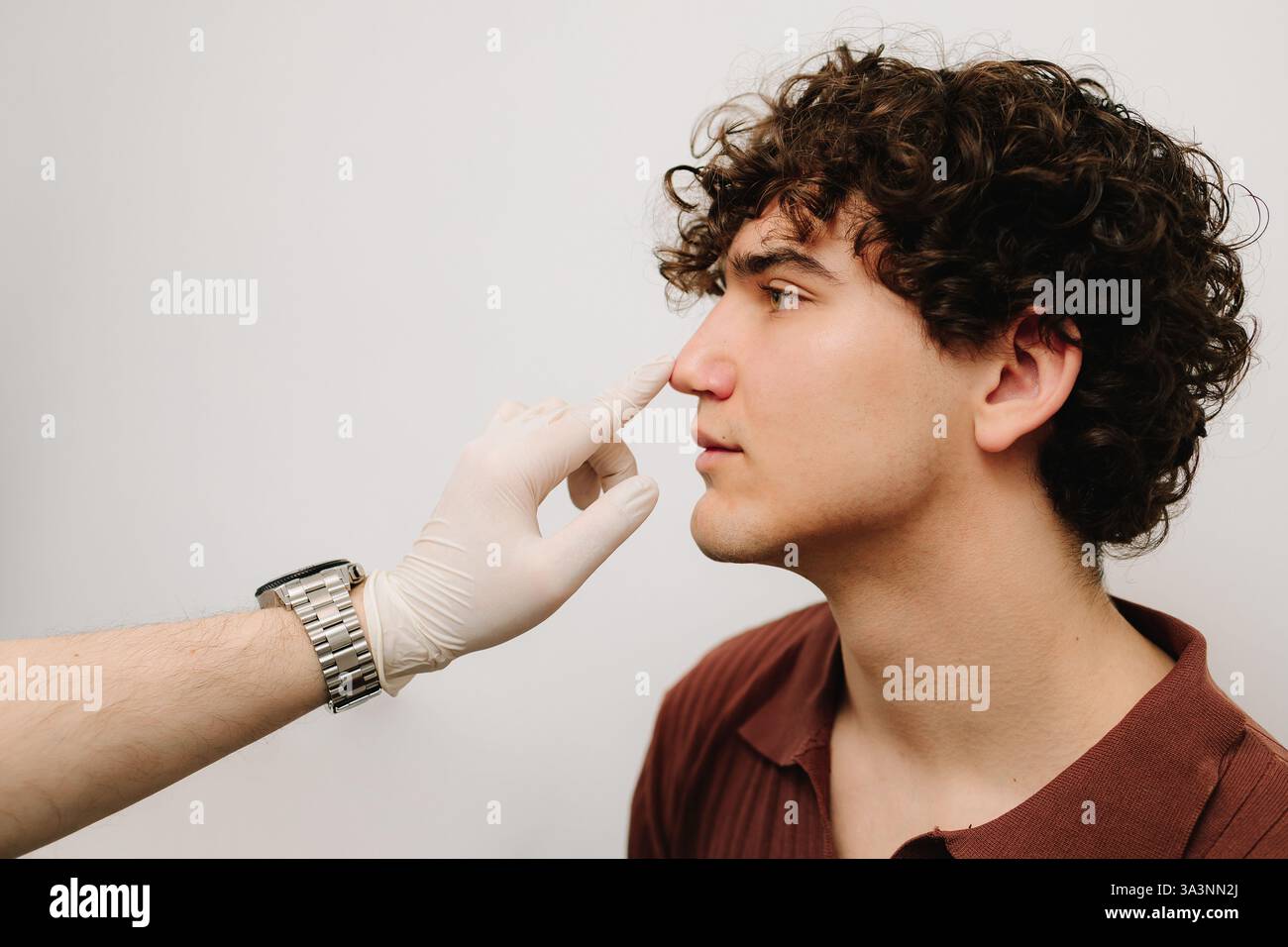 Rhinoplasty surgery preparation for man. ENT is touching nose and ...