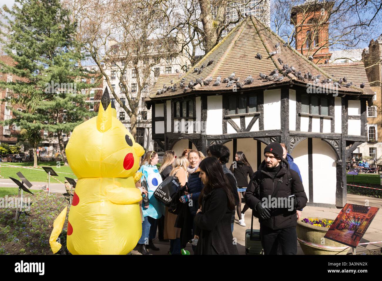 Tourists and a Pokémon Pikachu character in Soho Square in front of the ...