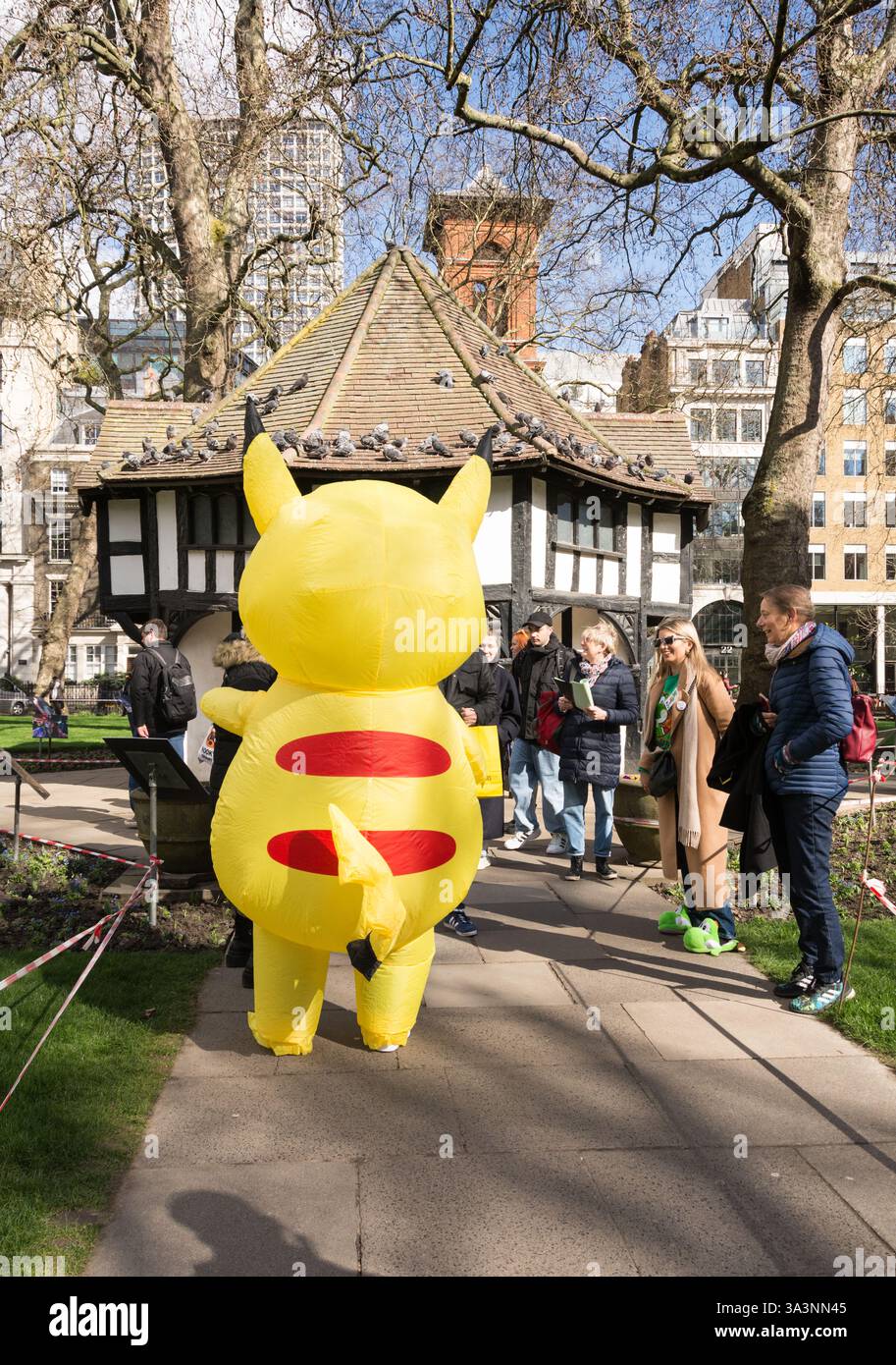 Tourists and a Pokémon Pikachu character in Soho Square in front of the ...