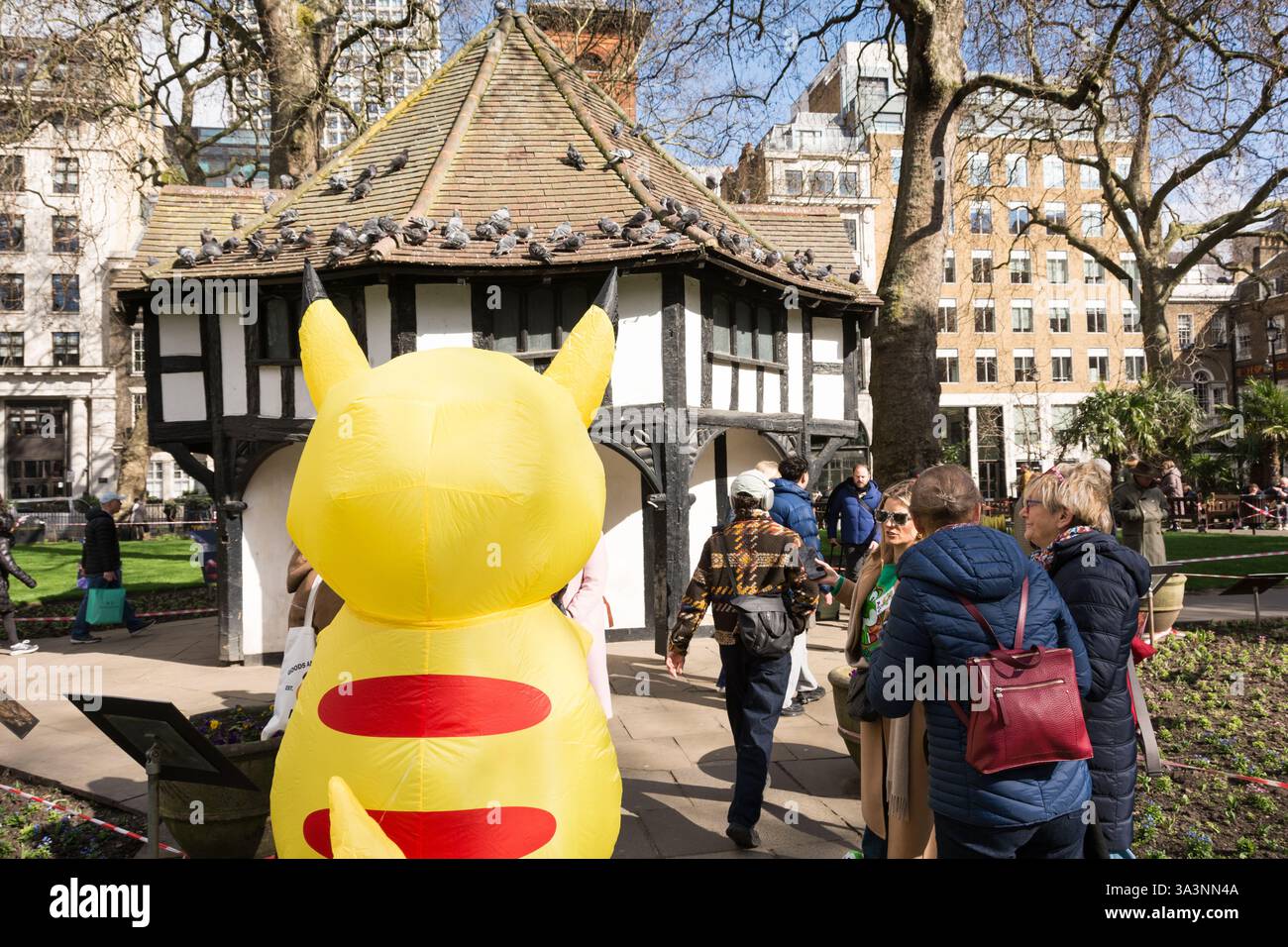 Tourists and a Pokémon Pikachu character in Soho Square in front of the ...