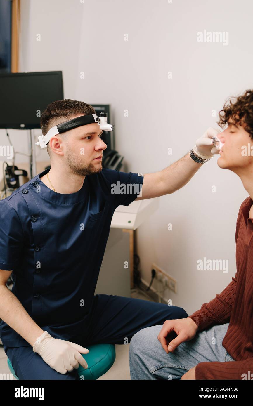 ENT doctor checking nose of man patient with rhinoscope. Rhinoscopy ...