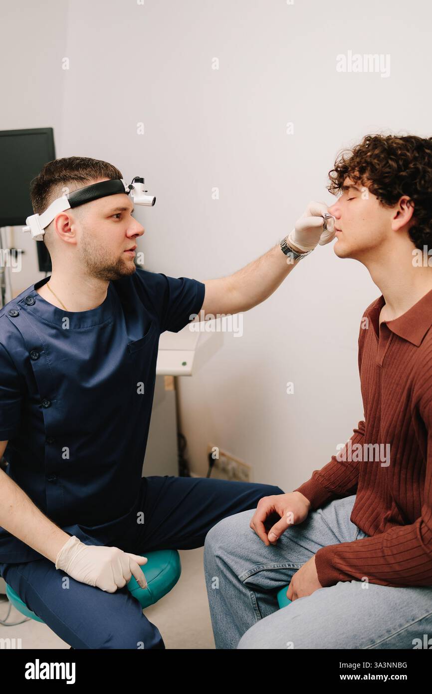 ENT doctor checking nose of man patient with rhinoscope. Rhinoscopy ...
