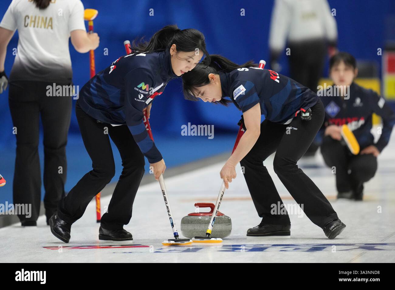 South Korea's Kim Su-ji and Kim Min-ji sweep during the match against ...
