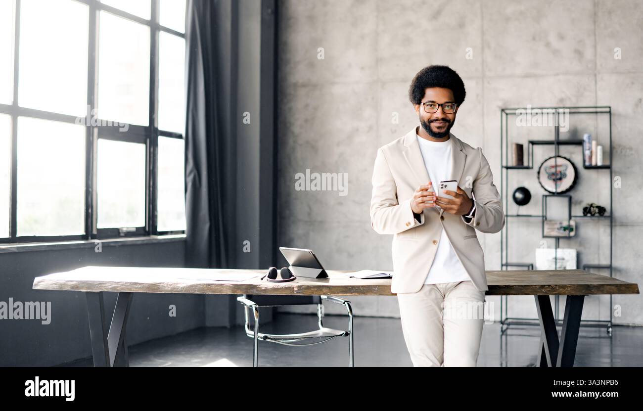 A young Brazilian businessman interacting with his smartphone in a ...