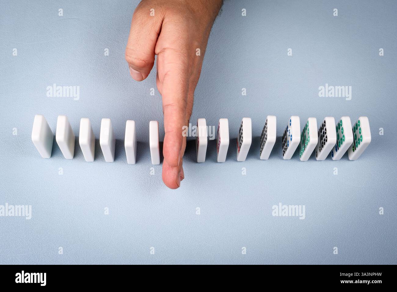 Dominoes and human hand on a light background Stock Photo - Alamy