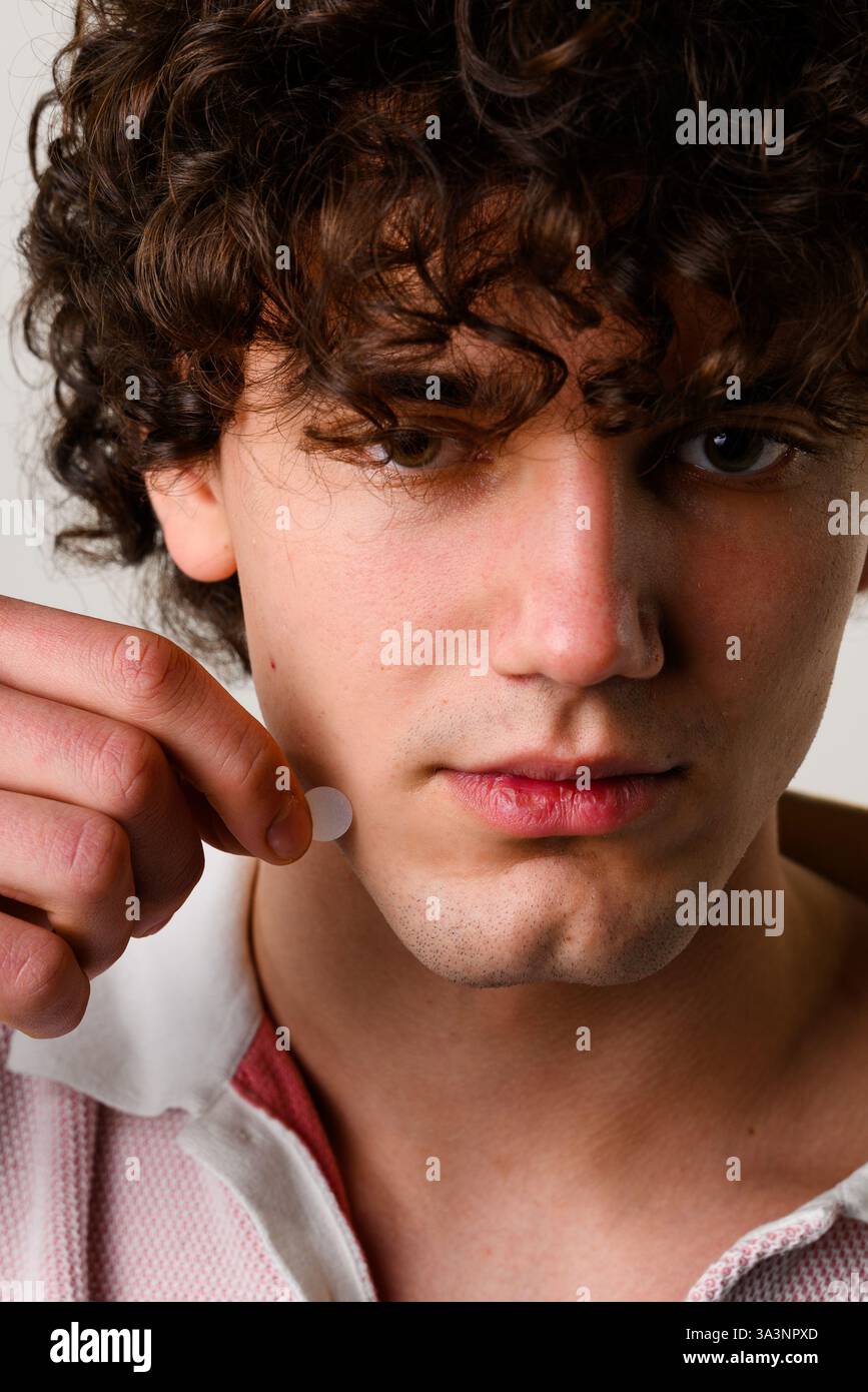 Young man uses acne stickers as bandage not to touch or squeeze pimple ...