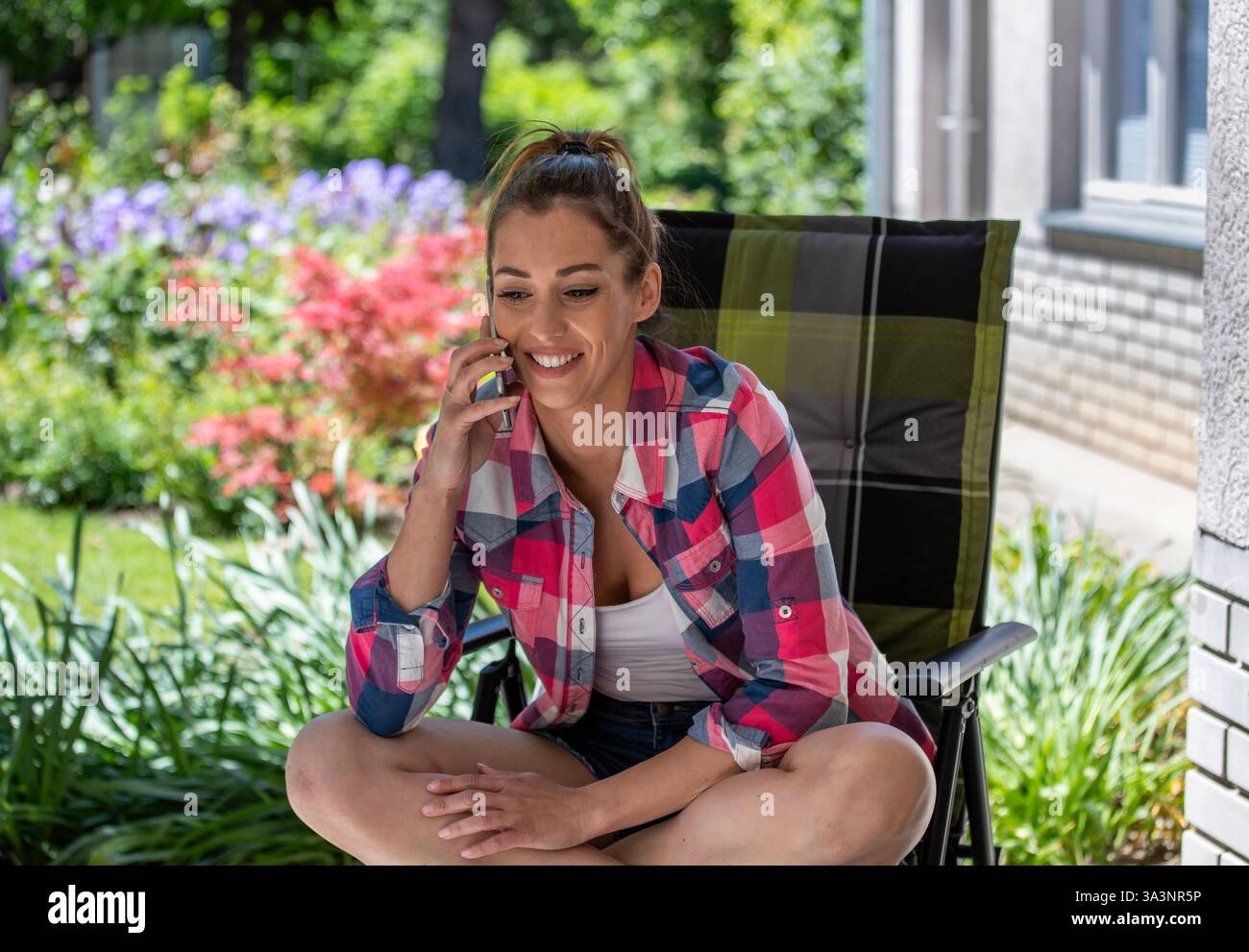Pretty woman siting comfortably in chair, laughing while talking on ...