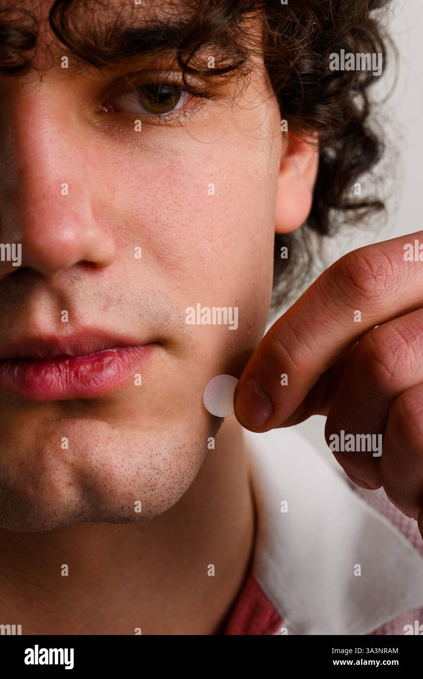 Using acne pimple patch to clean the face from zits. Young man uses ...