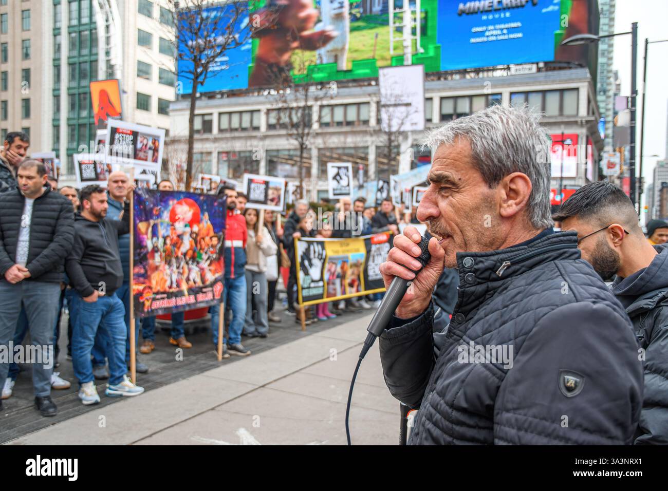 A senior man speaks to a group of people in a protest by the Syrian ...