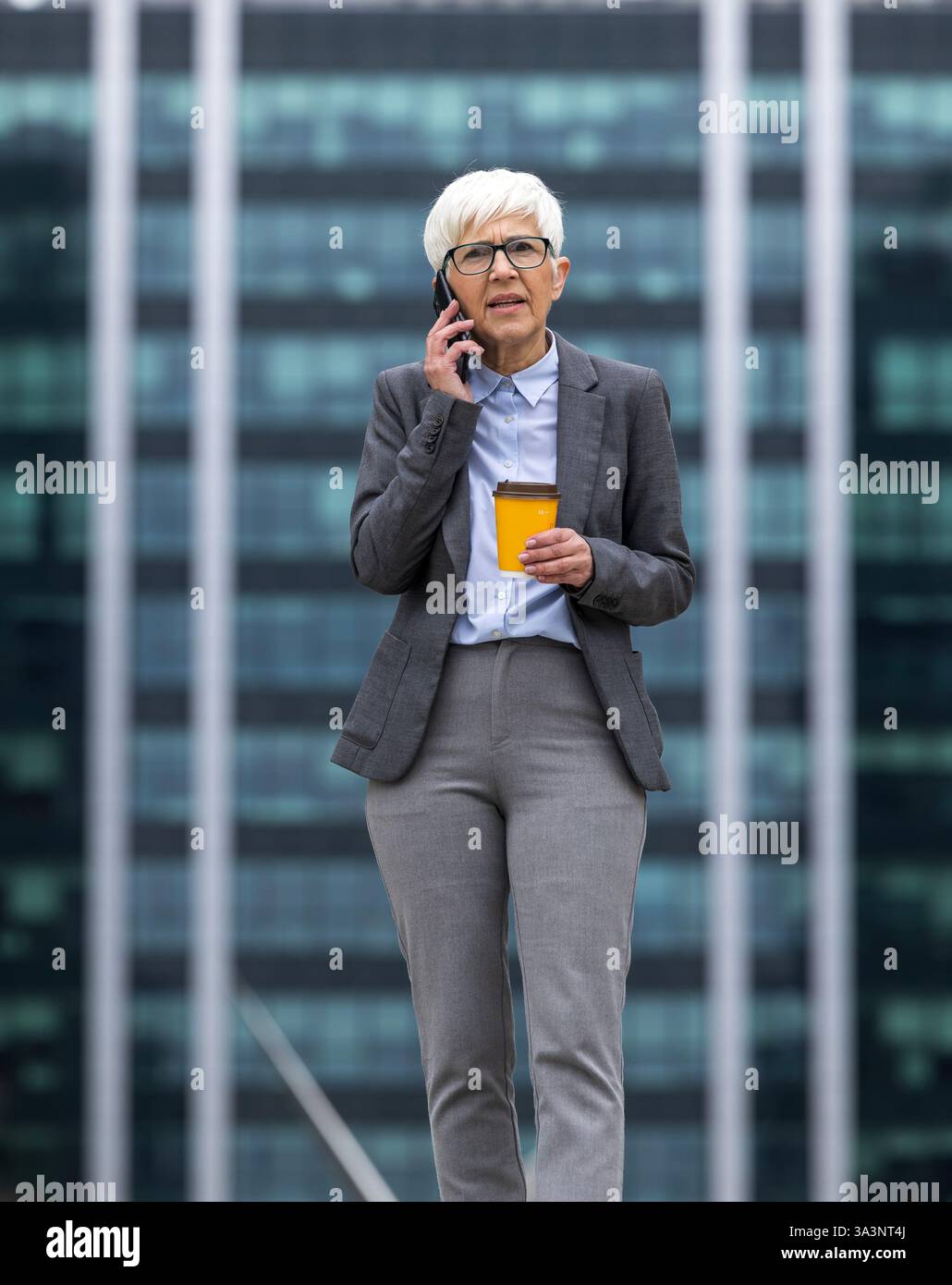 Female business woman is engaged in phone call while sipping coffee ...