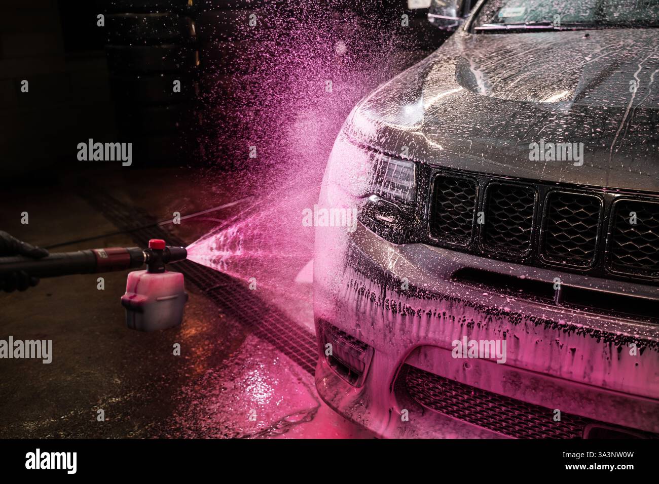 Applying pink foam on the car by using the applicator. The process of ...
