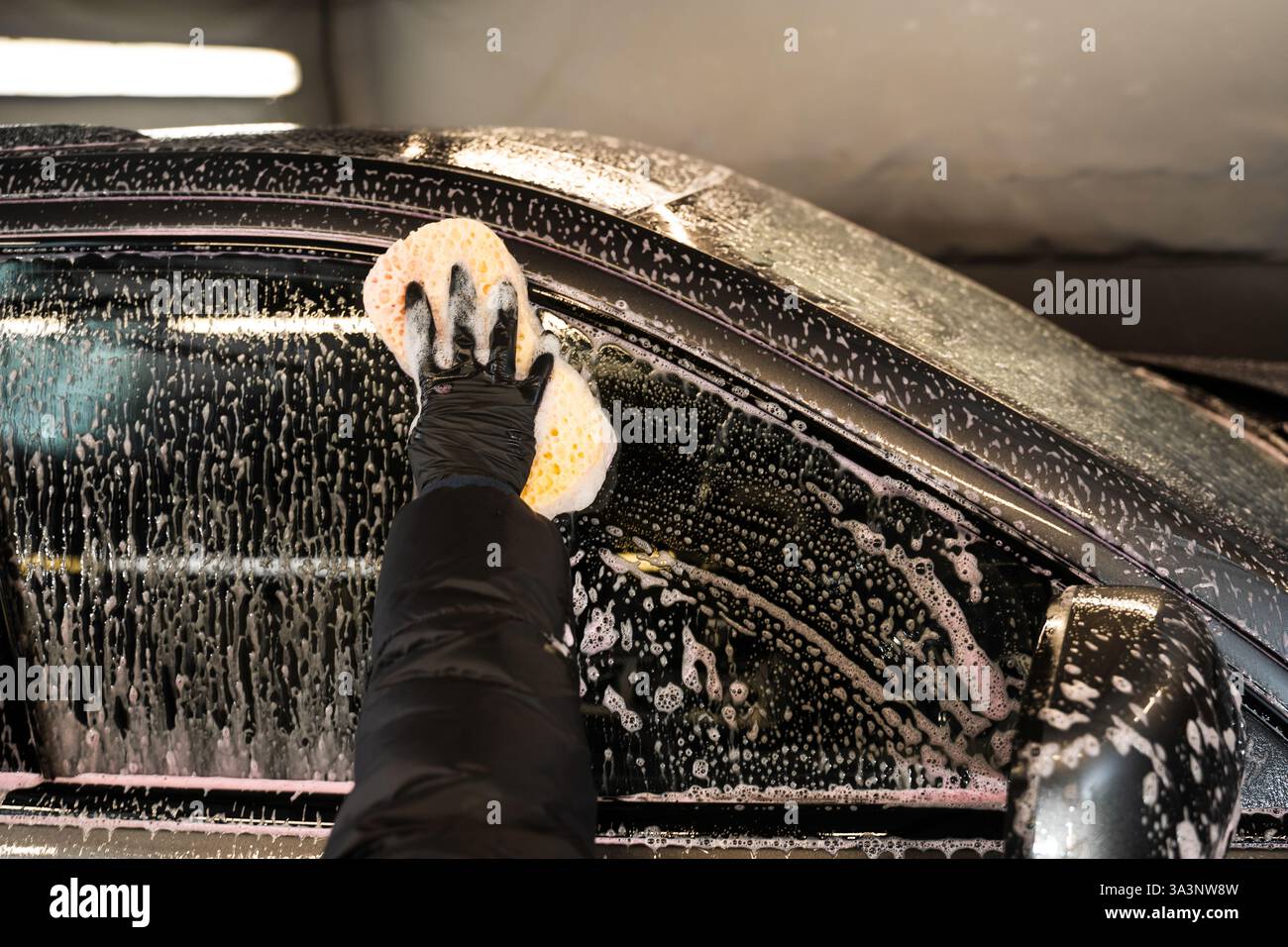 Cleaning the vehicle side window using a sponge and detergent during a ...