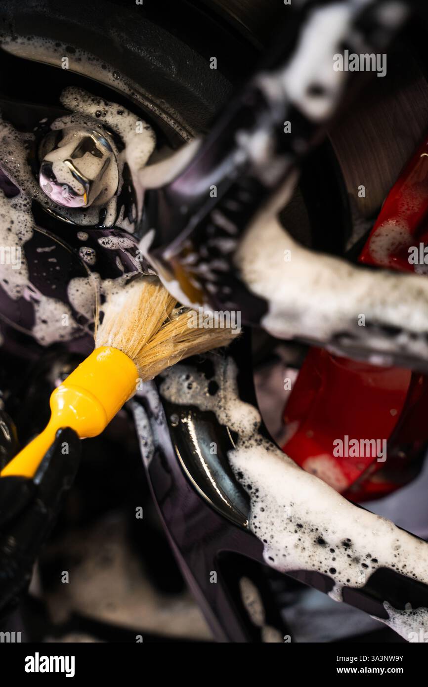 Washing wheel using detergent and brush. Vehicle detailing service at ...