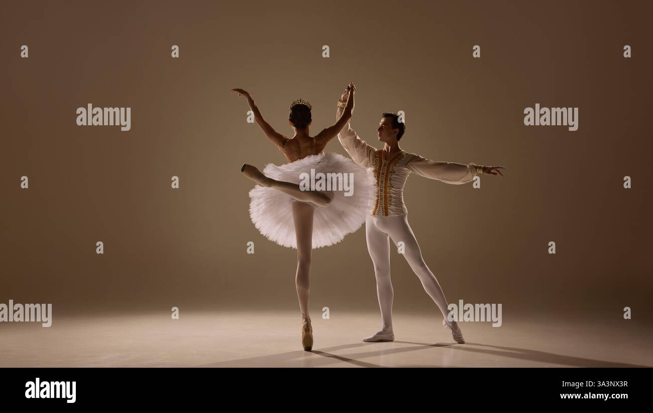 Ballerina balances on pointe, partner lifts her movement with steady ...