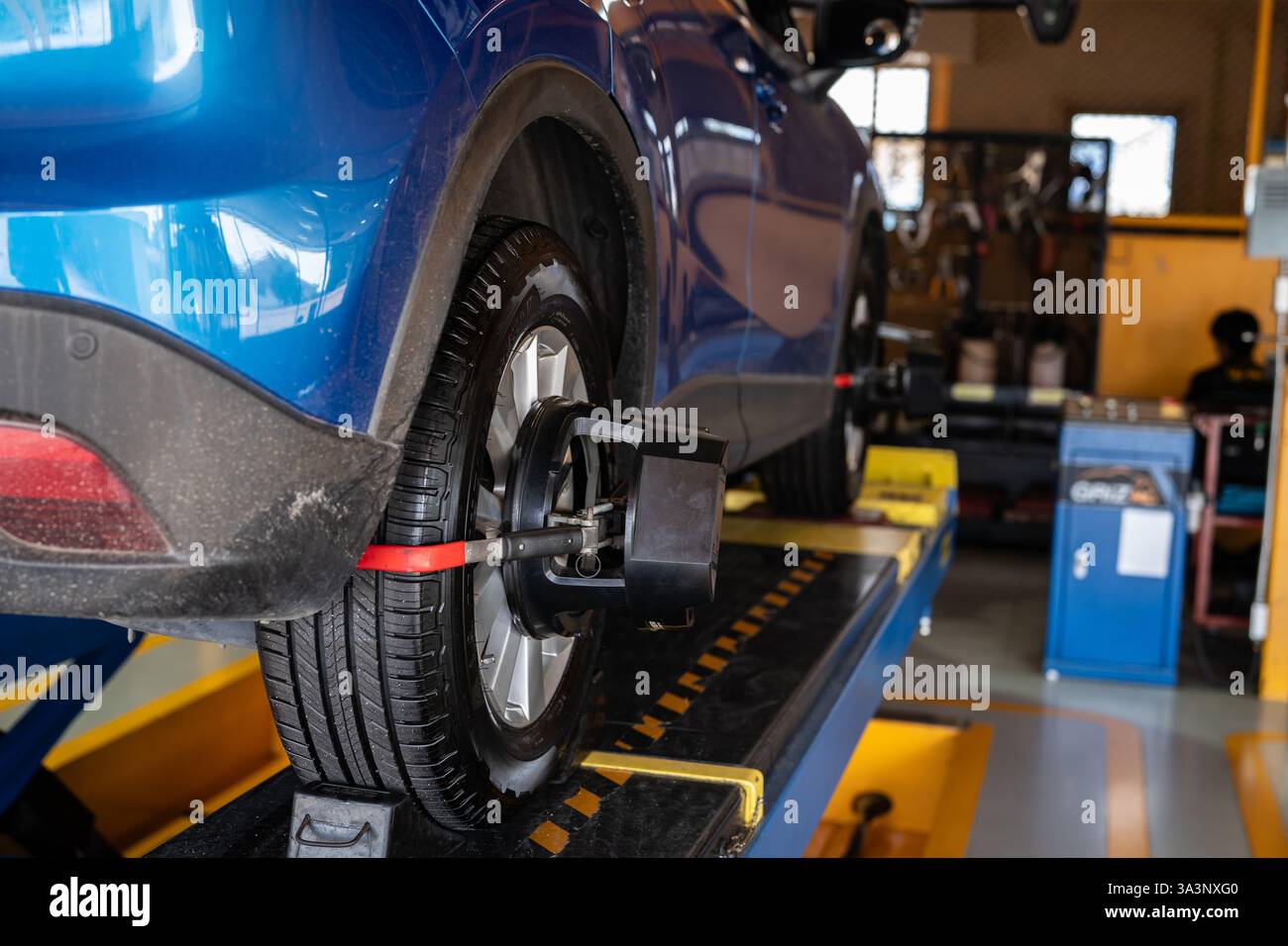 Wheel alignment equipment grip the tire of car wheel in car repair shop ...