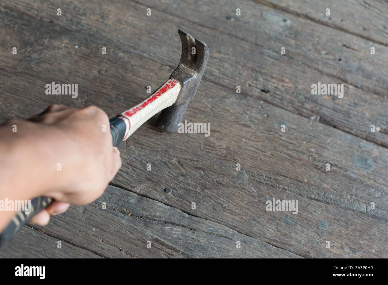 Hammer hold by hand of a man put on a wood floor Stock Photo - Alamy