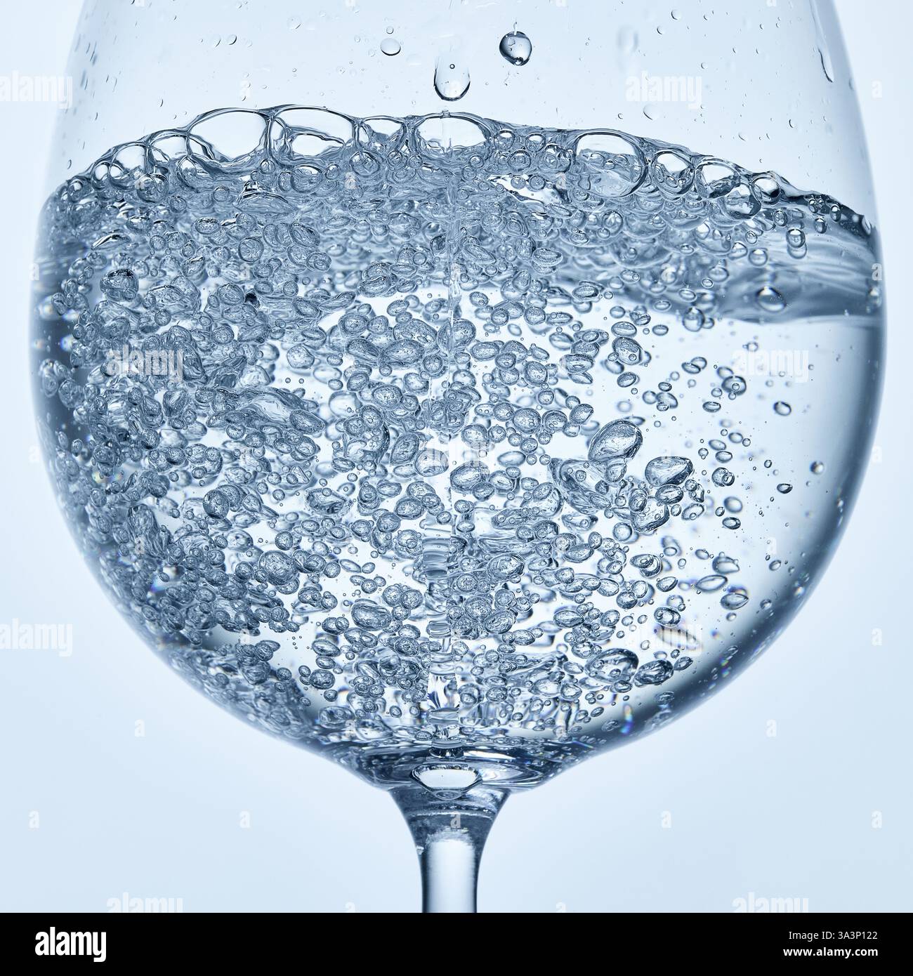 Close-up photo of water filled with bubbles in clear stemmed glass ...