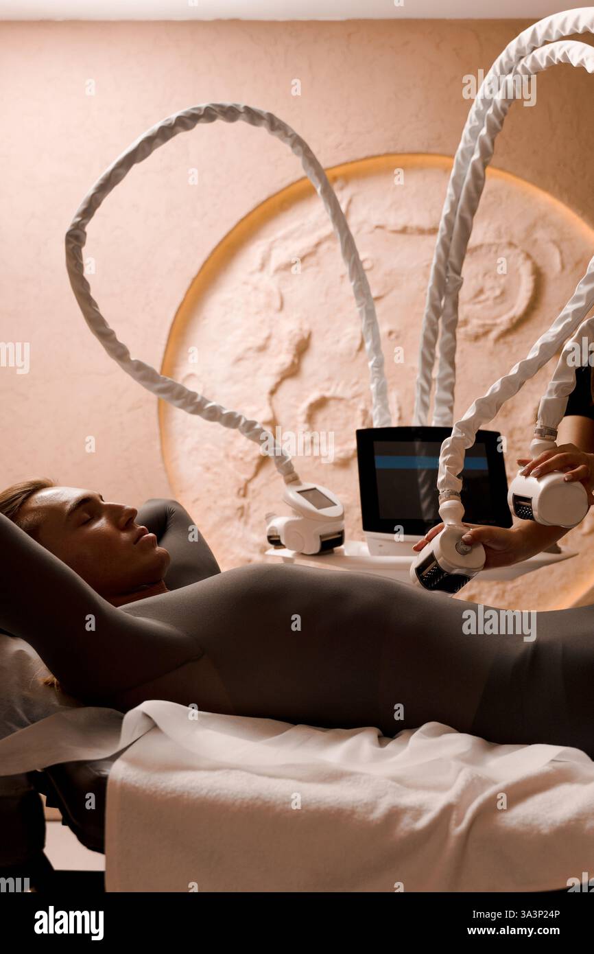 Lymphatic massage for a man with drainage equipment in beauty salon ...