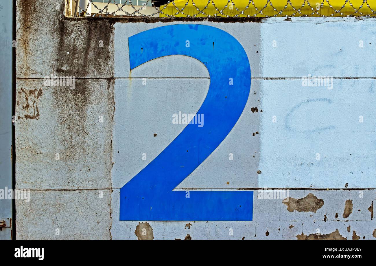 Number two in blue on white wall Stock Photo - Alamy