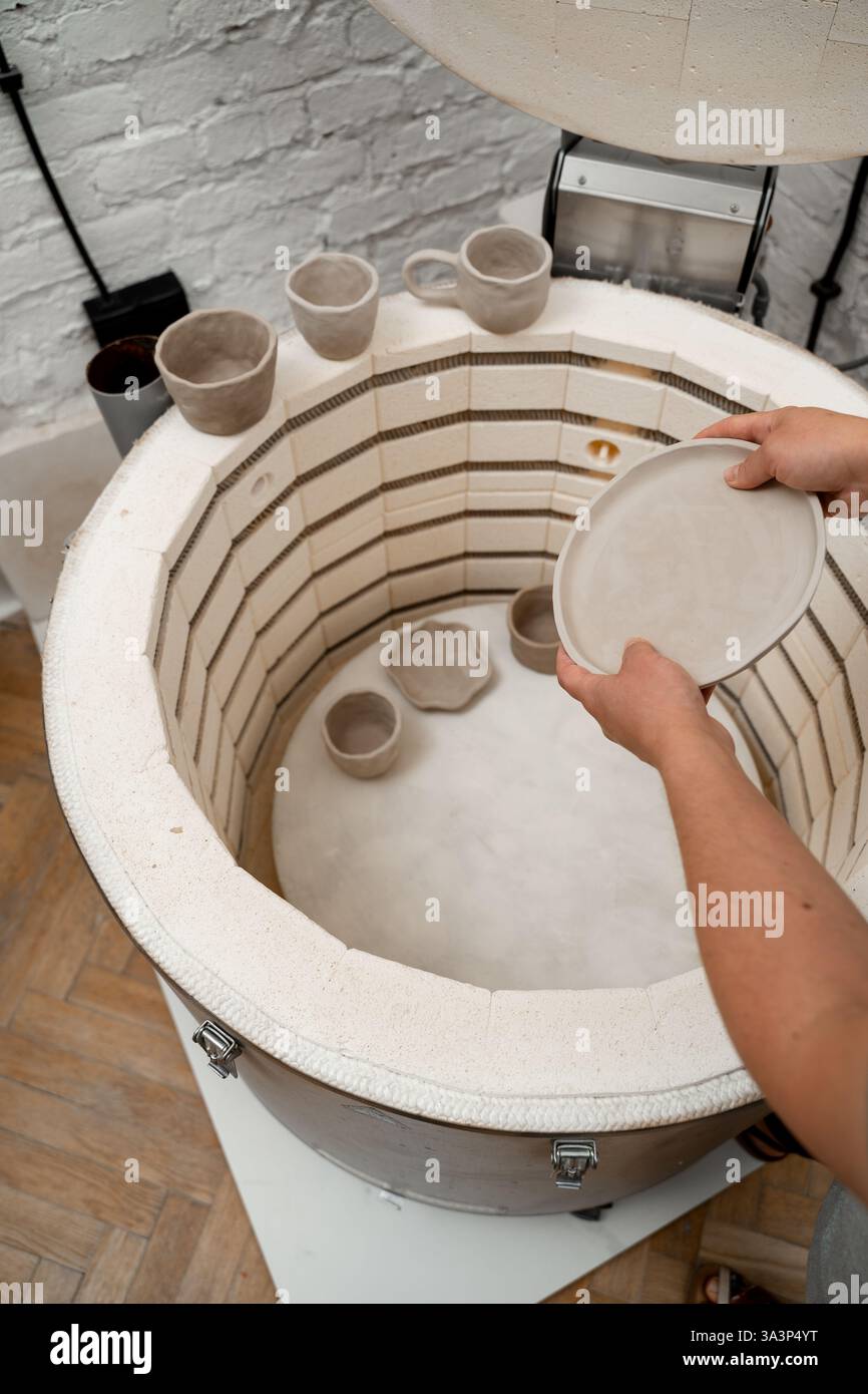 The process of firing clay products. Placing pottery in a muffle ...